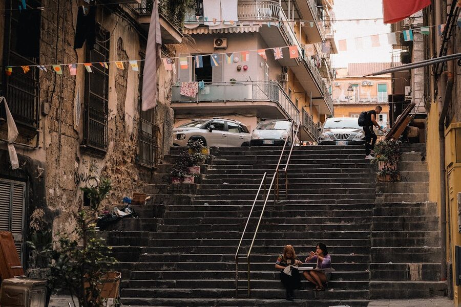 People walking on stone stairs in Naples with surrounding urban architecture