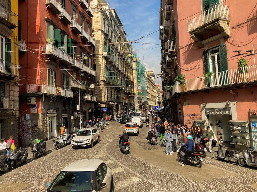 City street in Naples Italy with motor scooters and pedestrians on a sunny day
