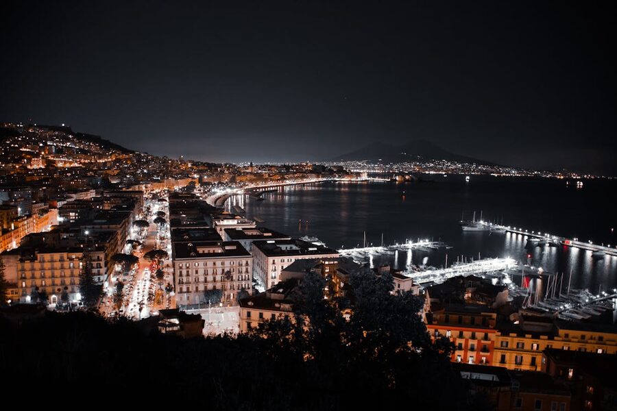 Aerial view of Naples coastline at night showing city lights along the bay