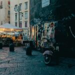 Evening street market in Naples with food vendors and crowds in narrow historic streets