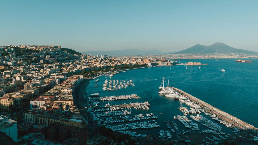 Aerial view of Naples harbour with boats and the city skyline under clear blue sky