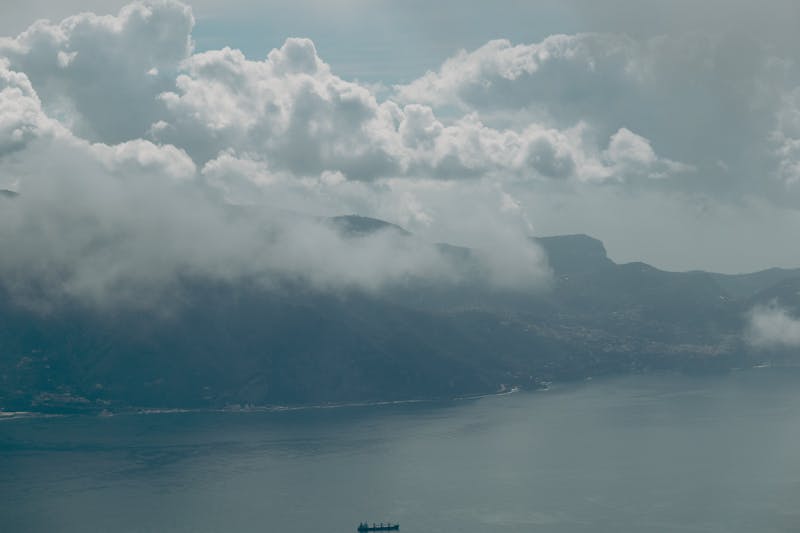 Scenic view of Naples coastline with dramatic clouds over the mountains and sea