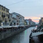 Naviglio Grande canal in Milan at evening with restaurants and reflections