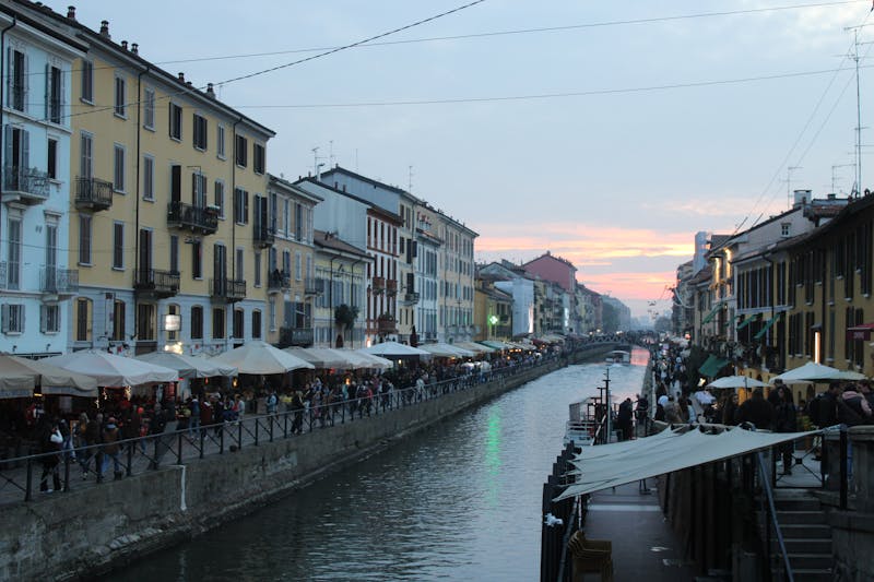 Naviglio Grande canal in Milan at evening with restaurants and reflections