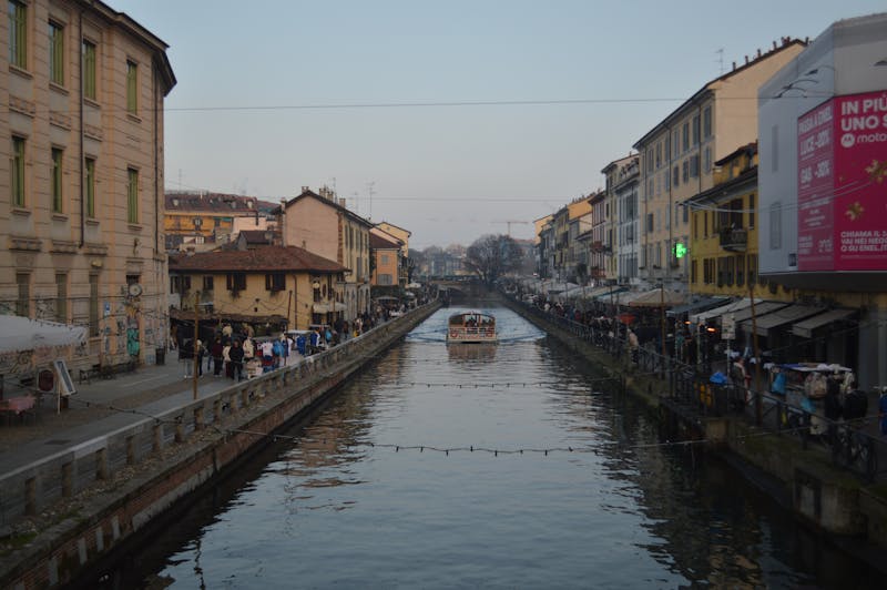 Milan Navigli canal at dusk with pedestrians and colorful buildings