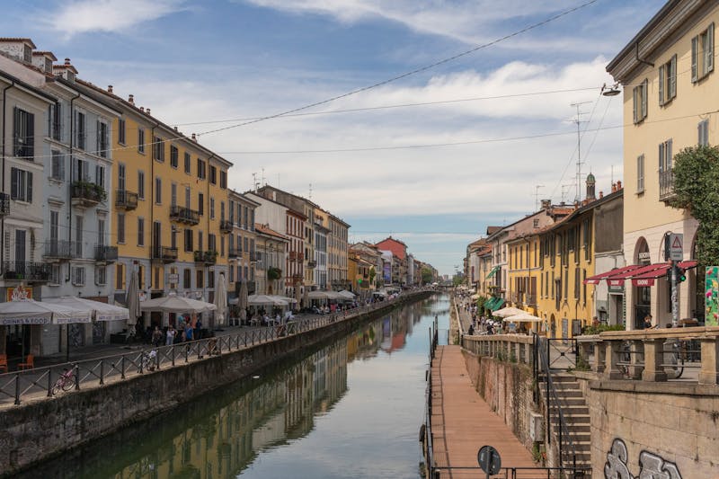 Colorful buildings and outdoor cafes lining a canal in Navigli Milan