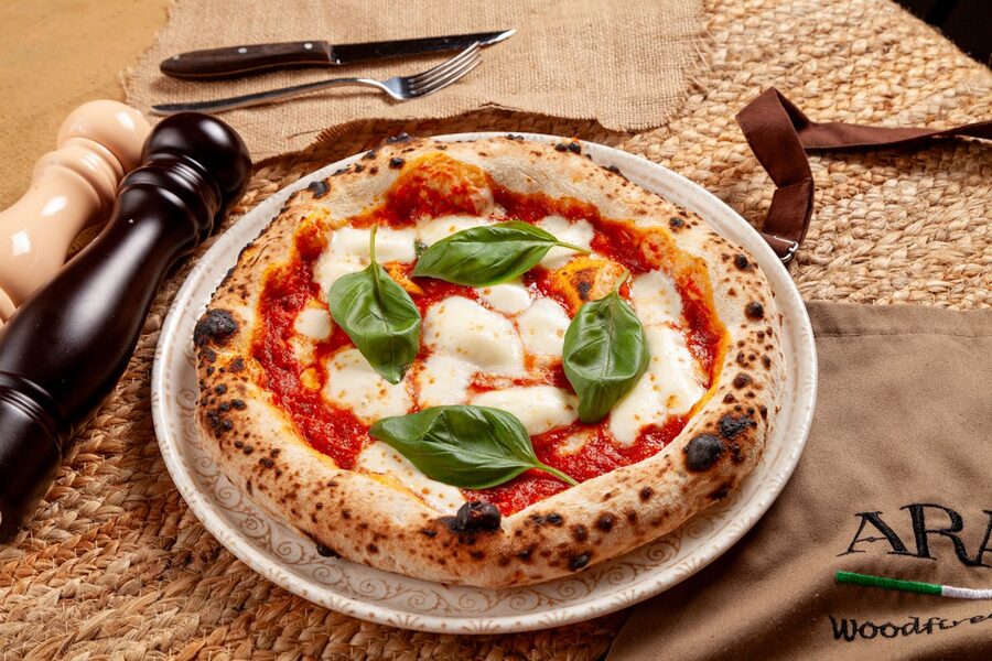 Authentic Neapolitan Margherita pizza with fresh basil and mozzarella from wood-fired oven