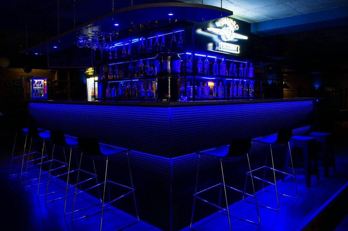 Sleek bar counter illuminated with blue neon lights