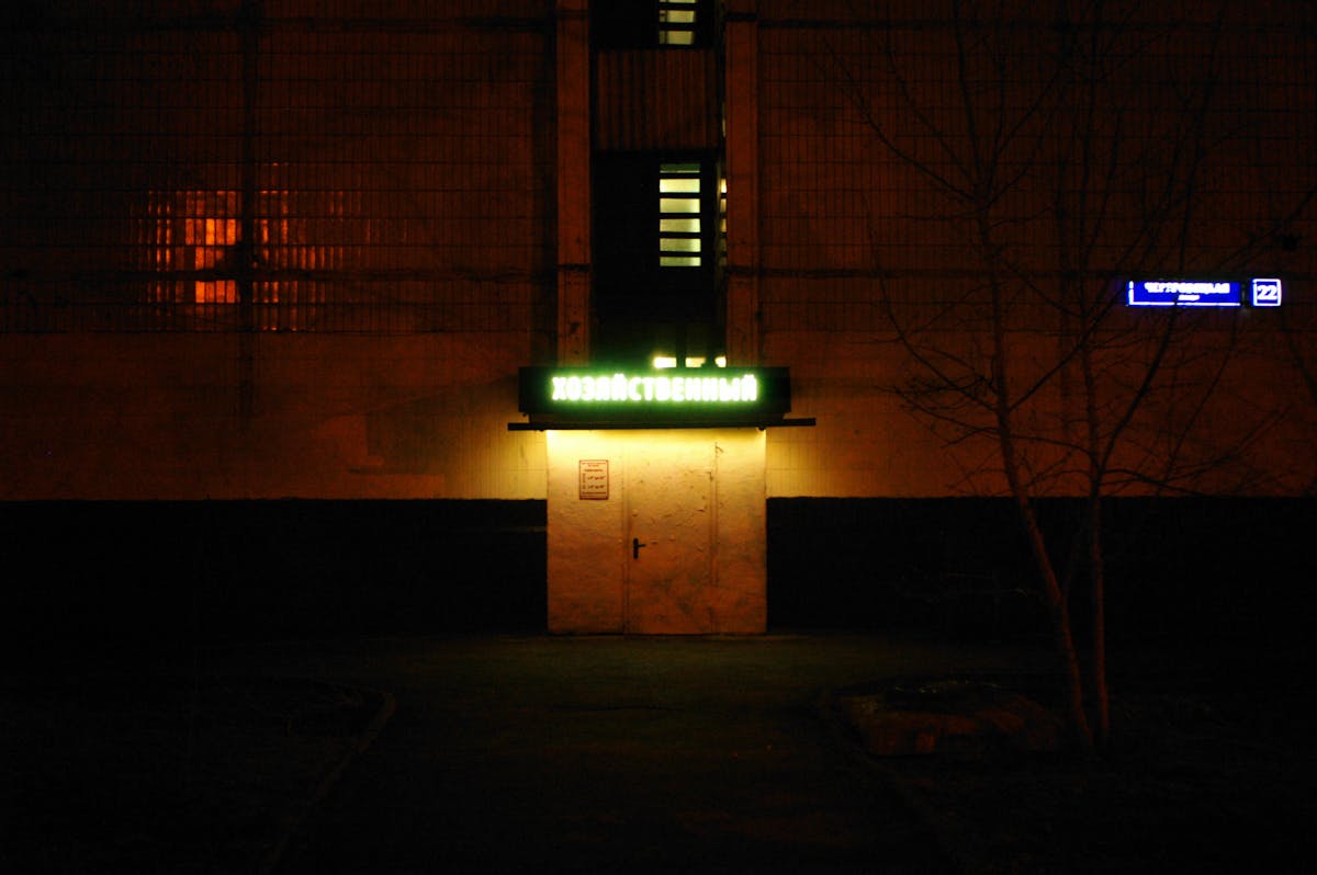 Neon lights illuminate a moody Parisian street at night