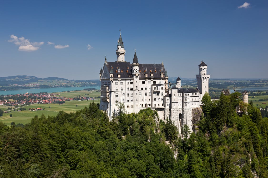 Panoramic view of Neuschwanstein Castle set against the Bavarian Alps and green valleys