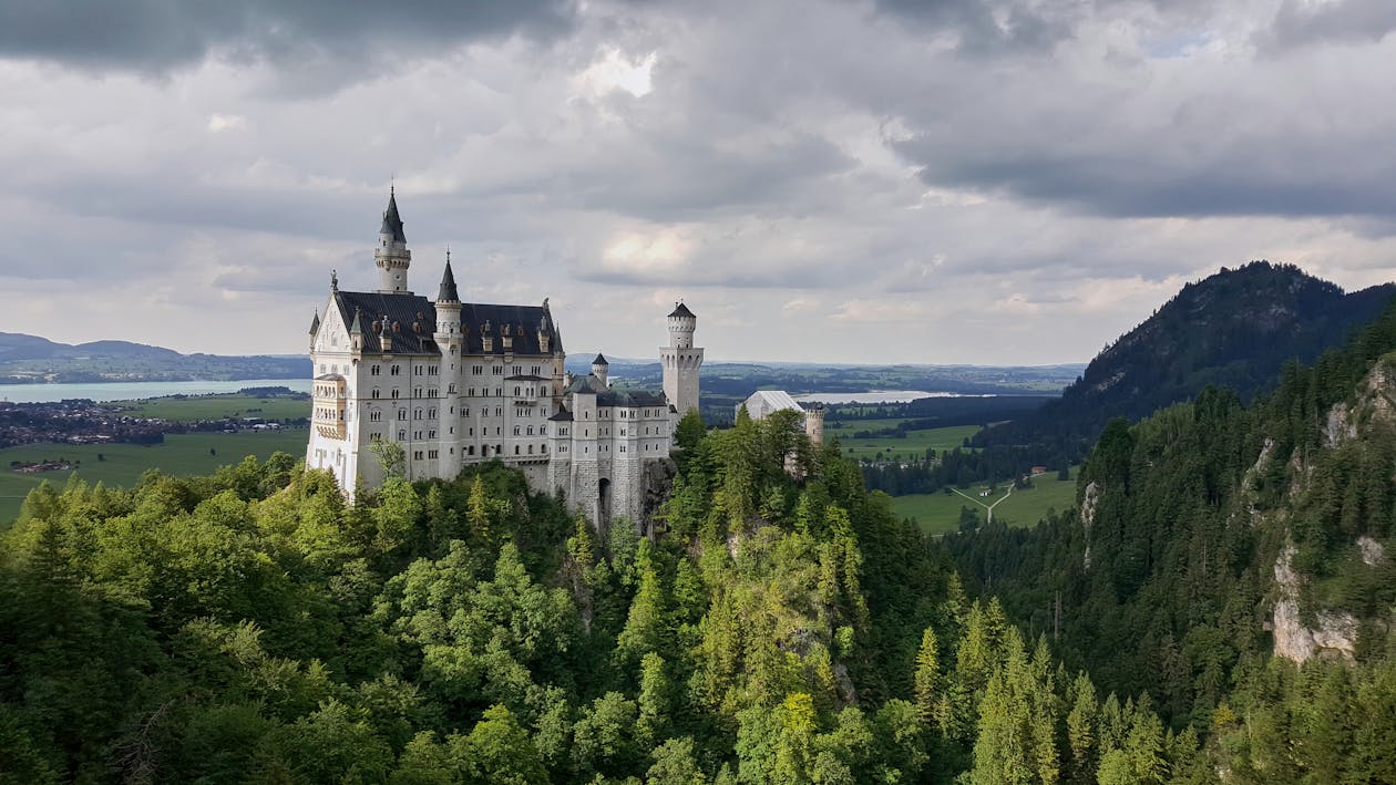 Neuschwanstein Castle on its hilltop surrounded by lush green summer forests in Bavaria
