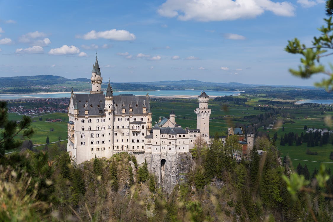 Neuschwanstein Castle perched on a hilltop under blue Bavarian skies