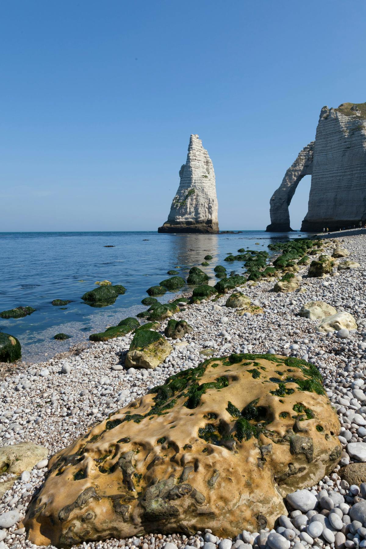 Breathtaking view of Etretat iconic cliffs and pebble beach in Normandie