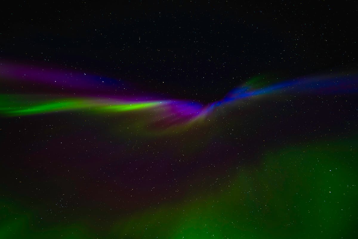 Vivid Northern Lights display with green purple and blue hues in Norway night sky