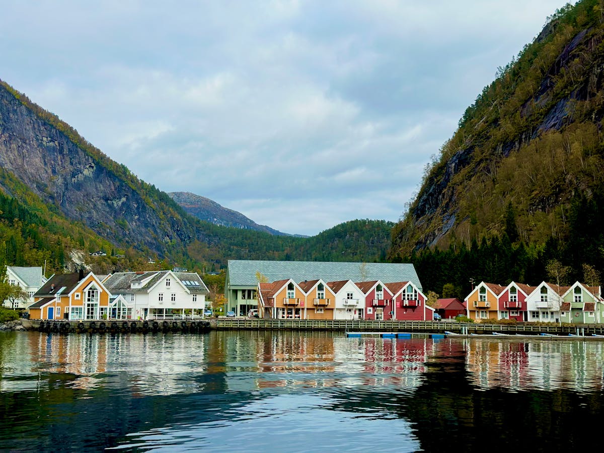 Colorful houses by a Norwegian fjord with mountain reflections