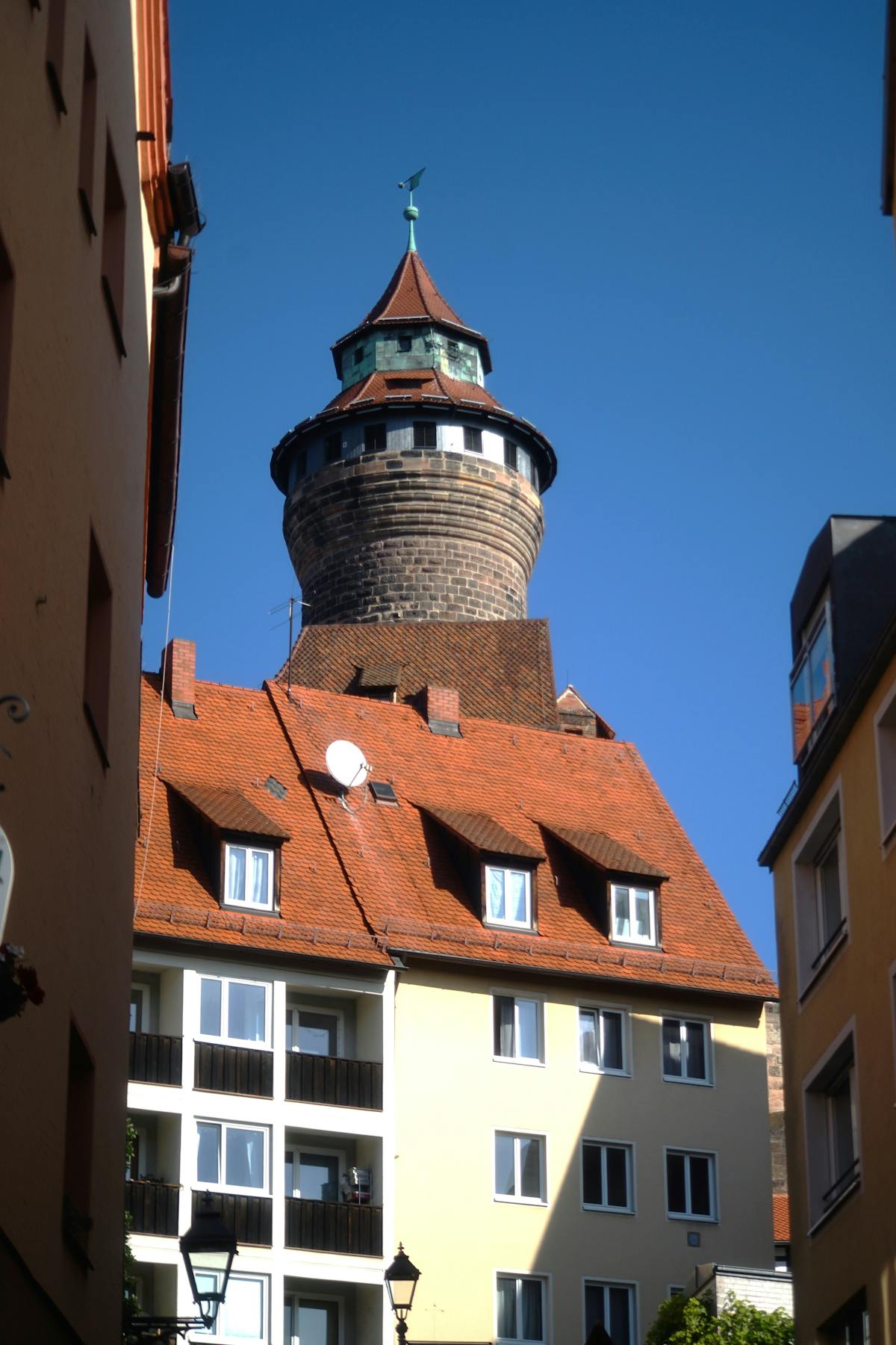 Nuremberg Castle Tower surrounded by historic buildings under clear blue sky