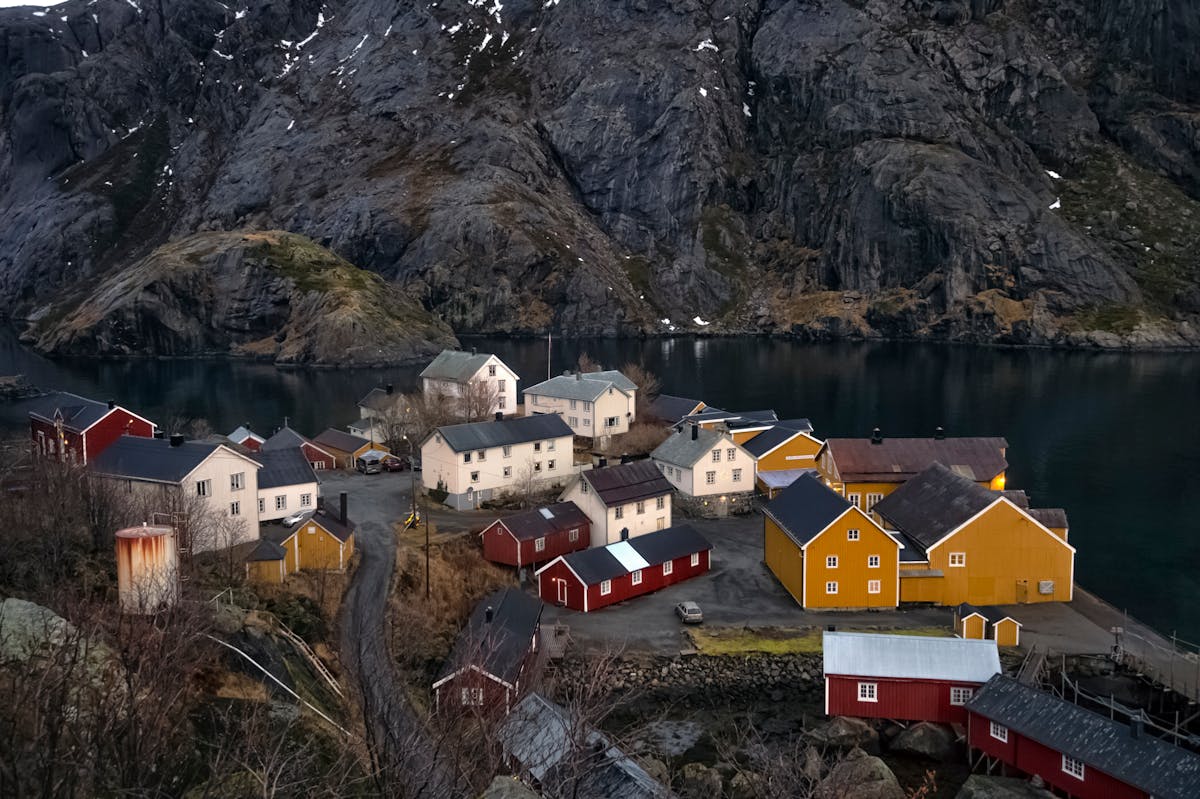 Aerial view of Nusfjord Norway with colorful houses by water surrounded by mountains
