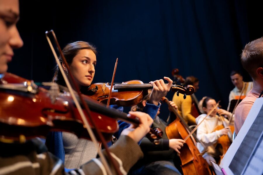 A violinist plays with an orchestra during a classical music performance