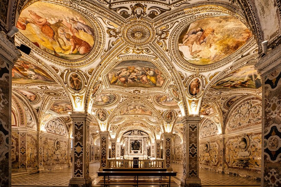 Richly decorated crypt interior with intricate frescoes on walls and ceiling