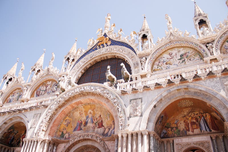 Detailed view of the ornate stone carvings and Gothic arches on St Marks Basilica in Venice