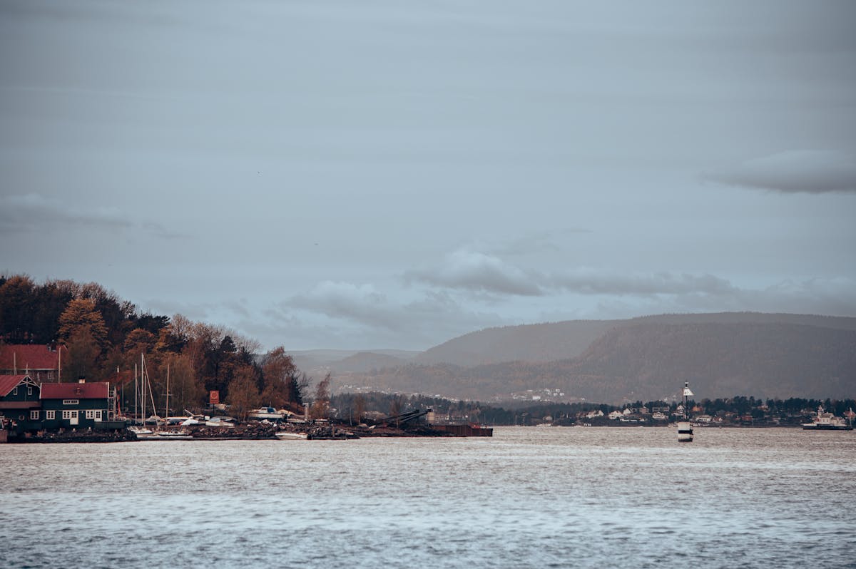 Oslo harbor view with watercraft and distant mountains