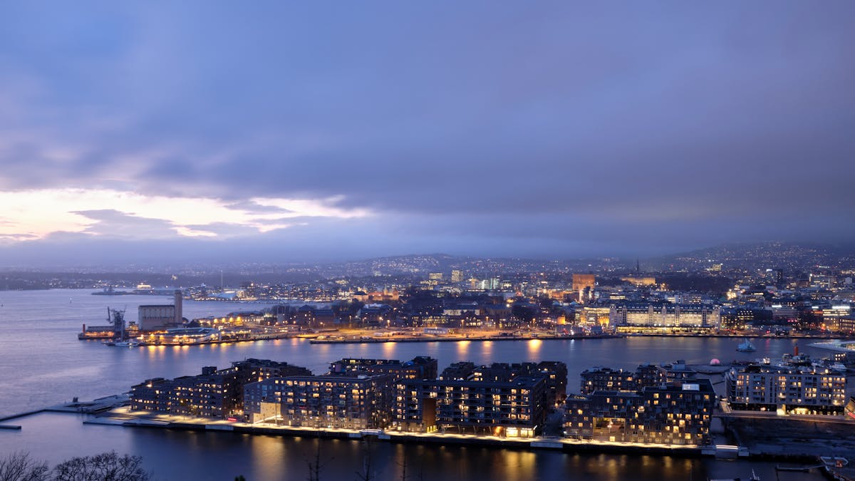 Oslo skyline at dusk with city lights reflecting on water