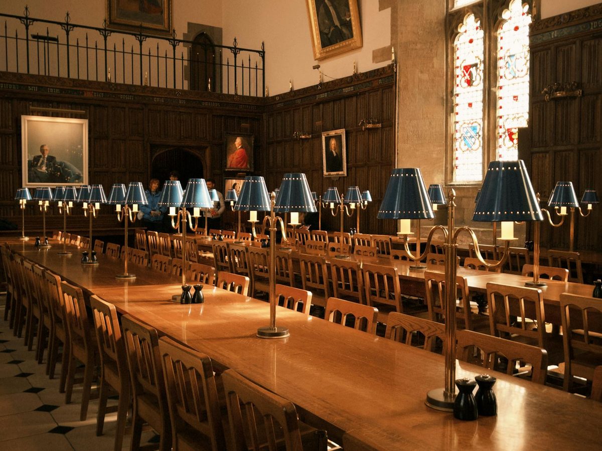 Elegant dining hall with wooden furniture and lamps in Oxford