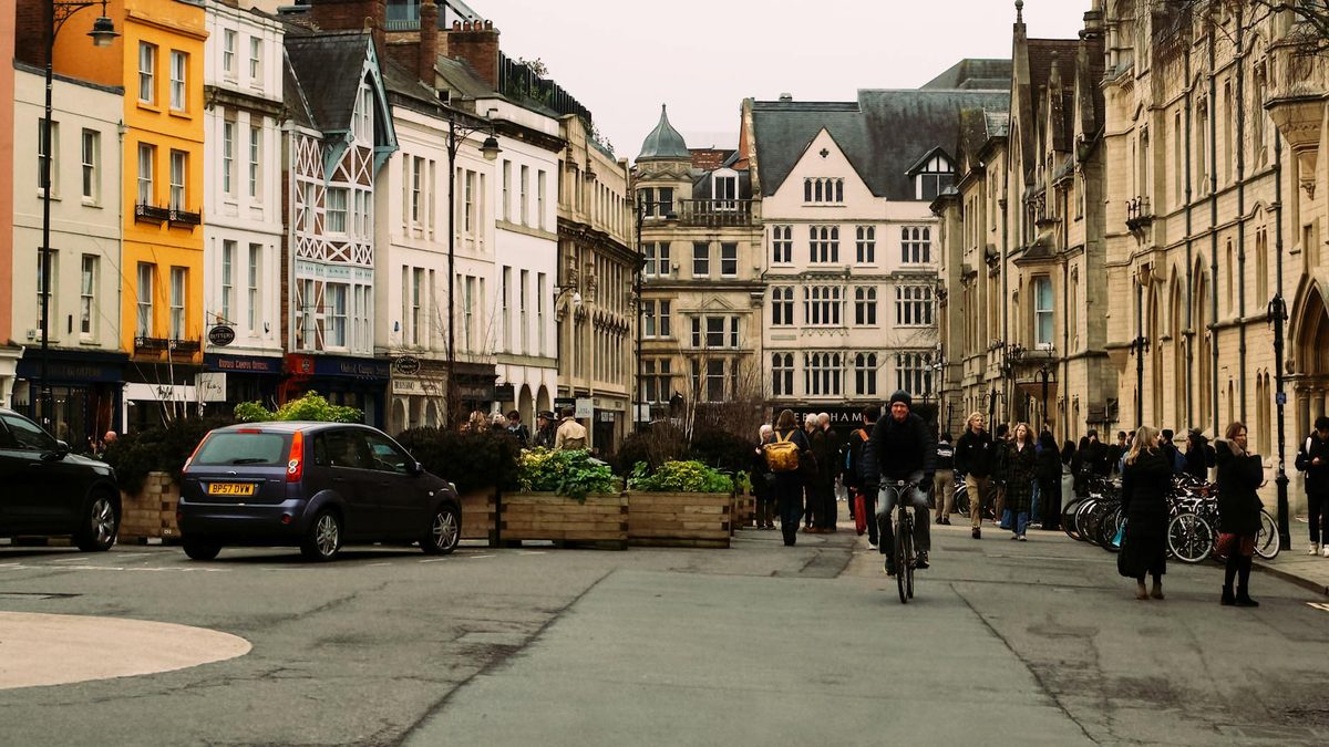 Busy Oxford street with cyclist and historic buildings