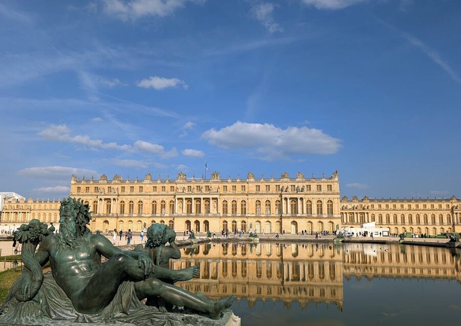 Breathtaking view of the Palace of Versailles with sculptured gardens in foreground