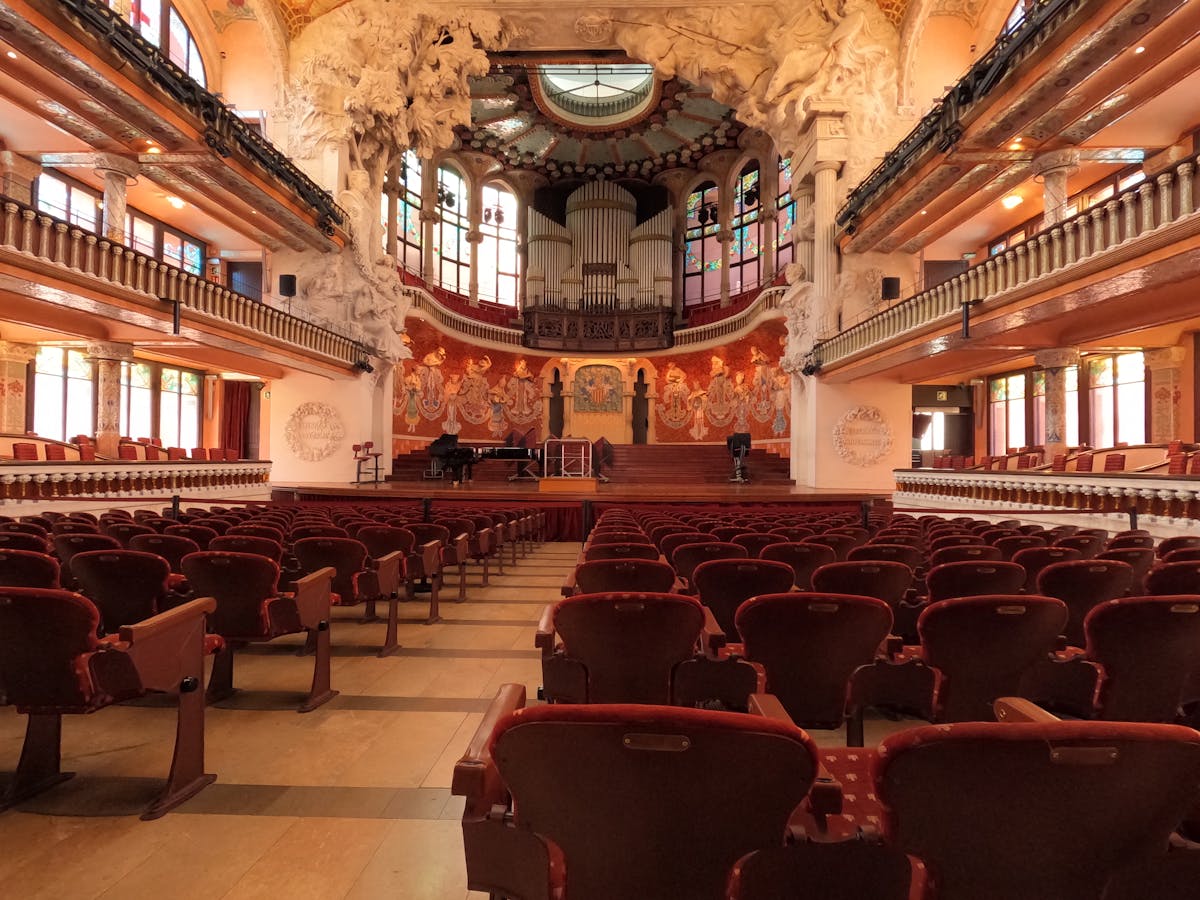Red chairs and ornate architectural details inside the Palau de la Musica Catalana concert hall