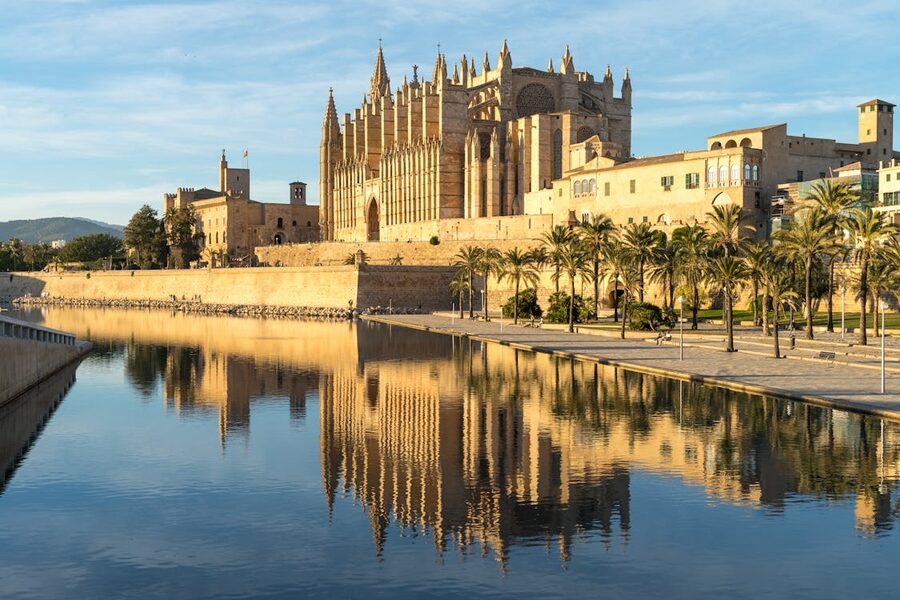 La Seu Cathedral in Palma de Mallorca reflecting in a tranquil waterway at golden hour