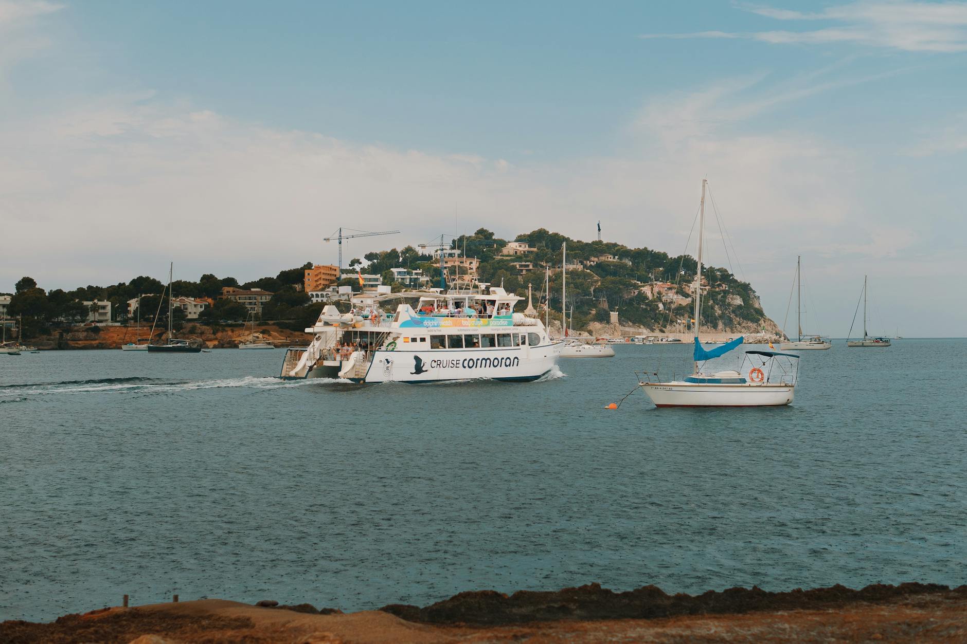 Boat floating on crystal clear turquoise water near the Mallorca coastline