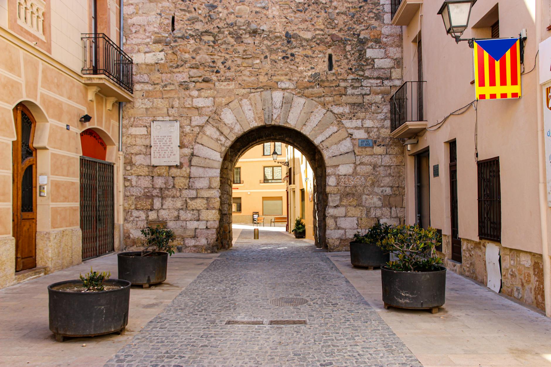 Stone archway leading to narrow street in old quarter of a Mediterranean town