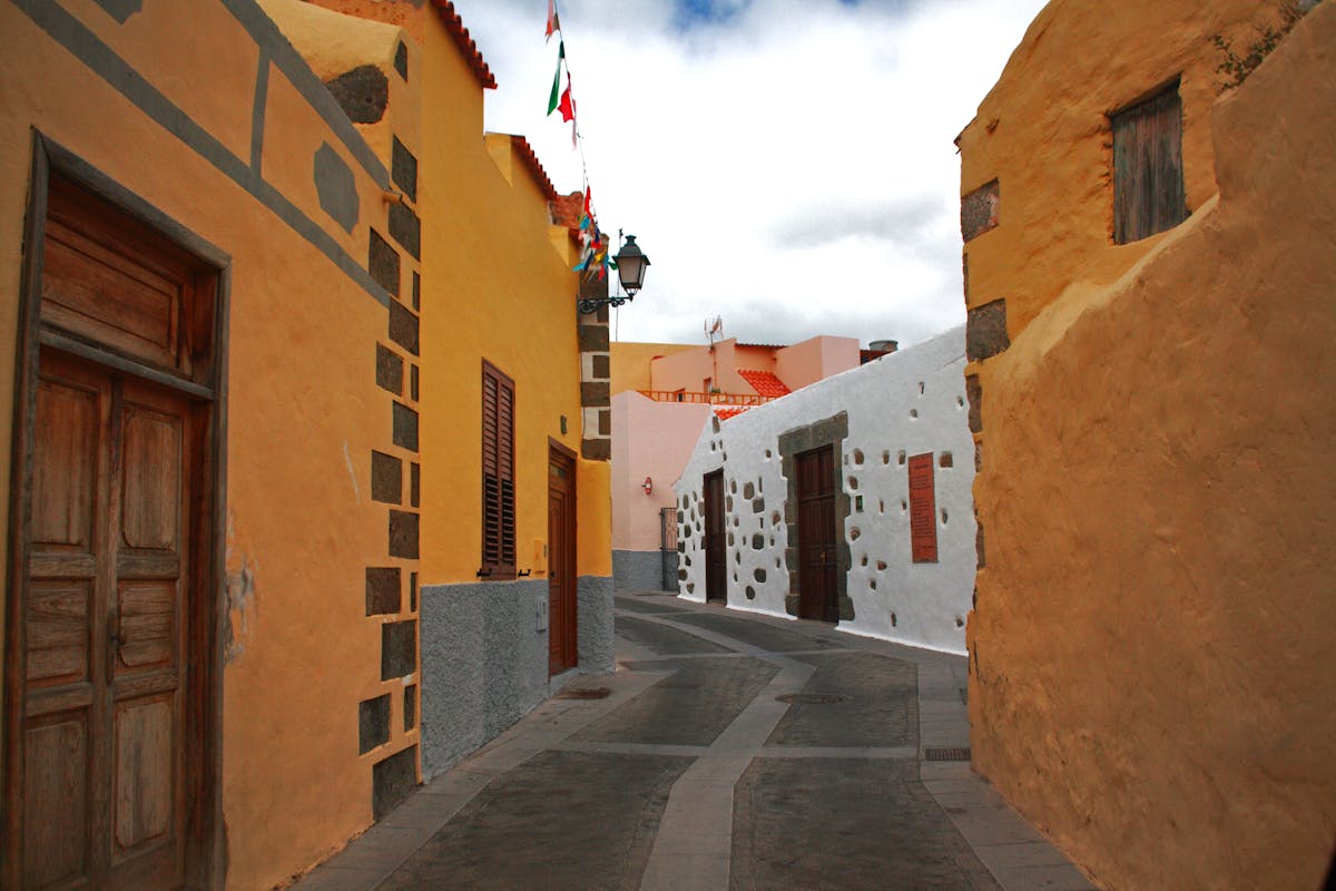 Narrow Spanish alley with yellow and white buildings in Palma de Mallorca old town
