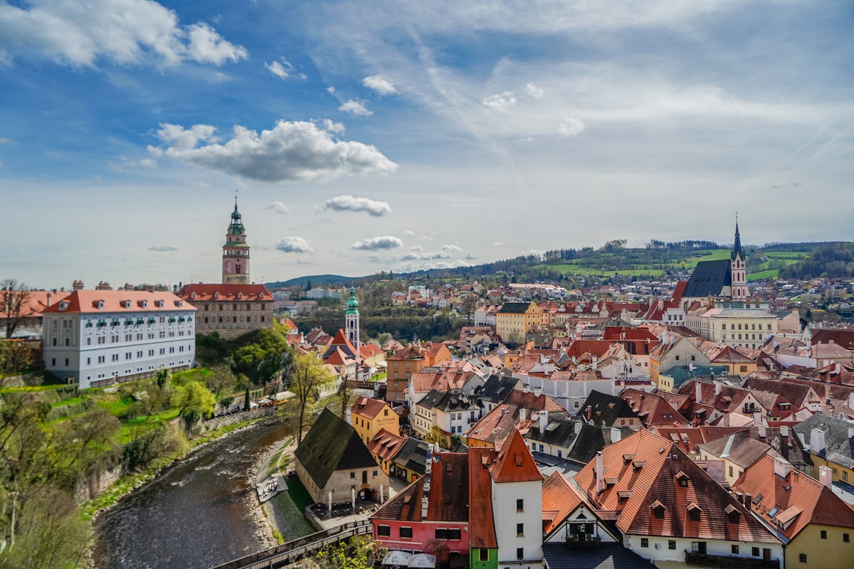 Panoramic view of Cesky Krumlov with historic buildings and Vltava River under a blue sky