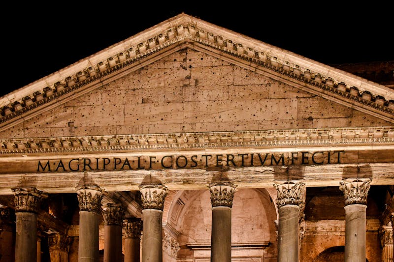 The Pantheon lit up at night with its Latin inscription visible above the columns