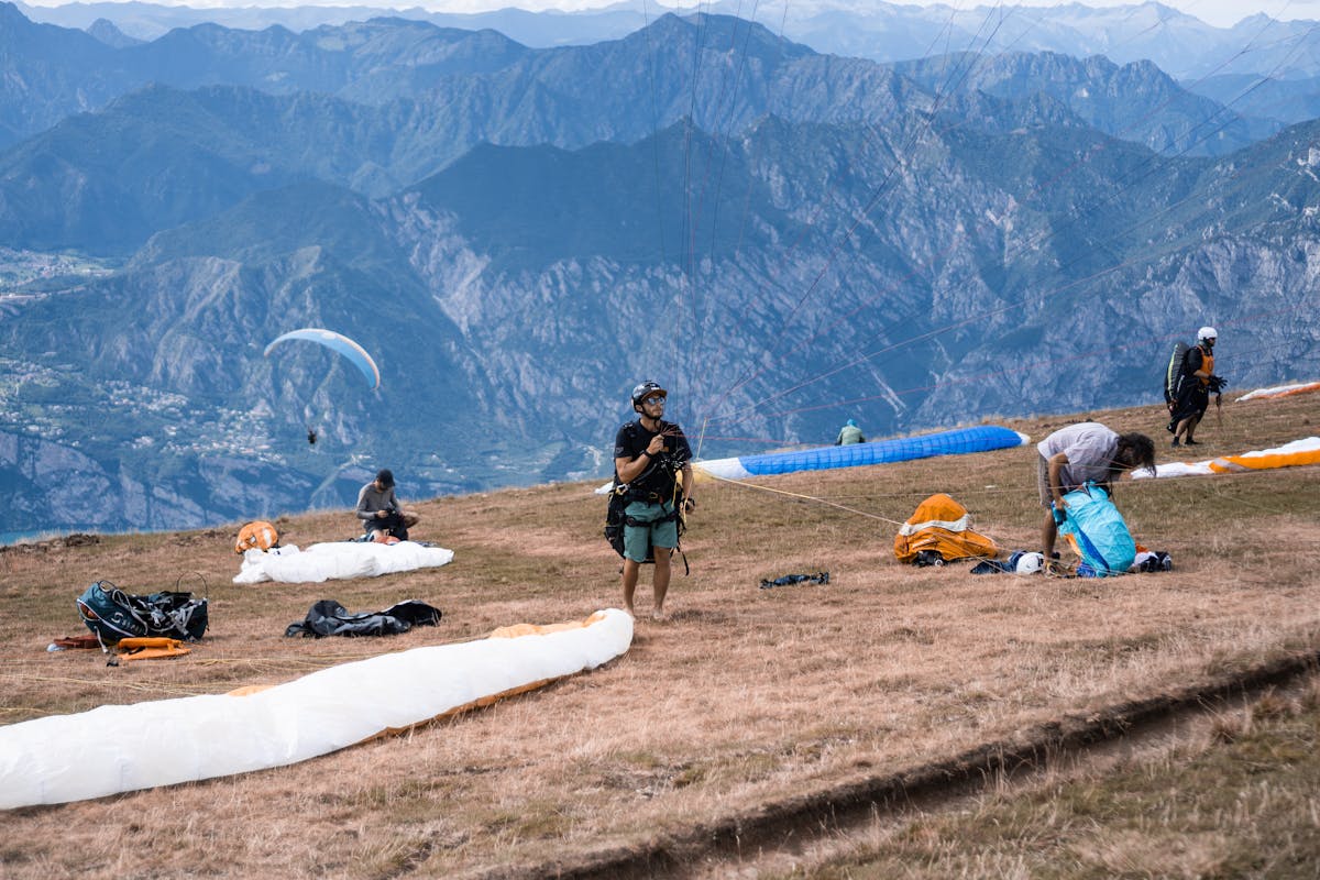 Paragliders setting up equipment on a mountain plateau