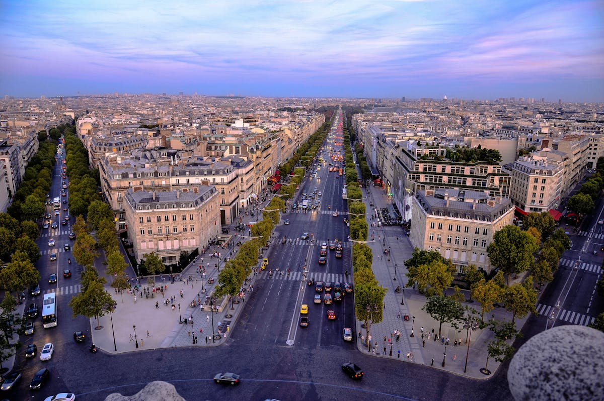 Aerial view of the Champs-Elysees in Paris at dusk with the city lights beginning to glow