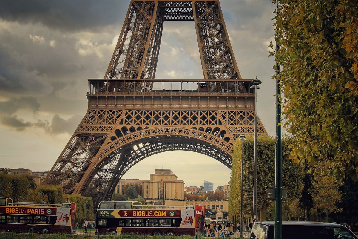 Eiffel Tower viewed from a Paris street with a sightseeing bus passing by