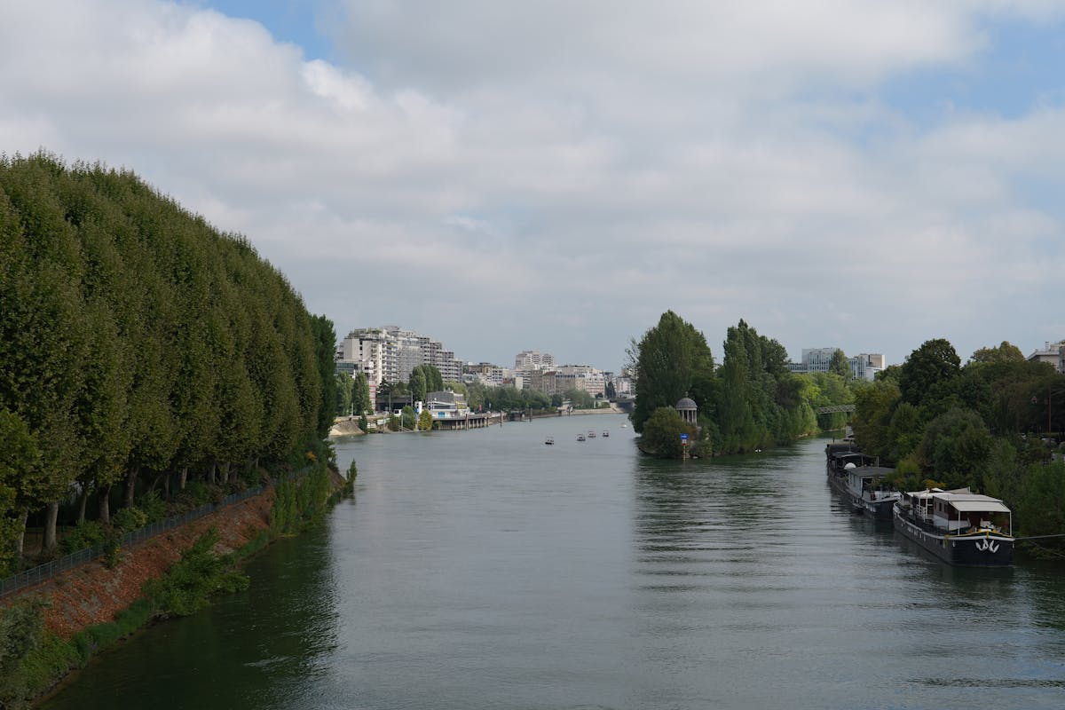 View of the Seine River with boats and the Paris city skyline in the background