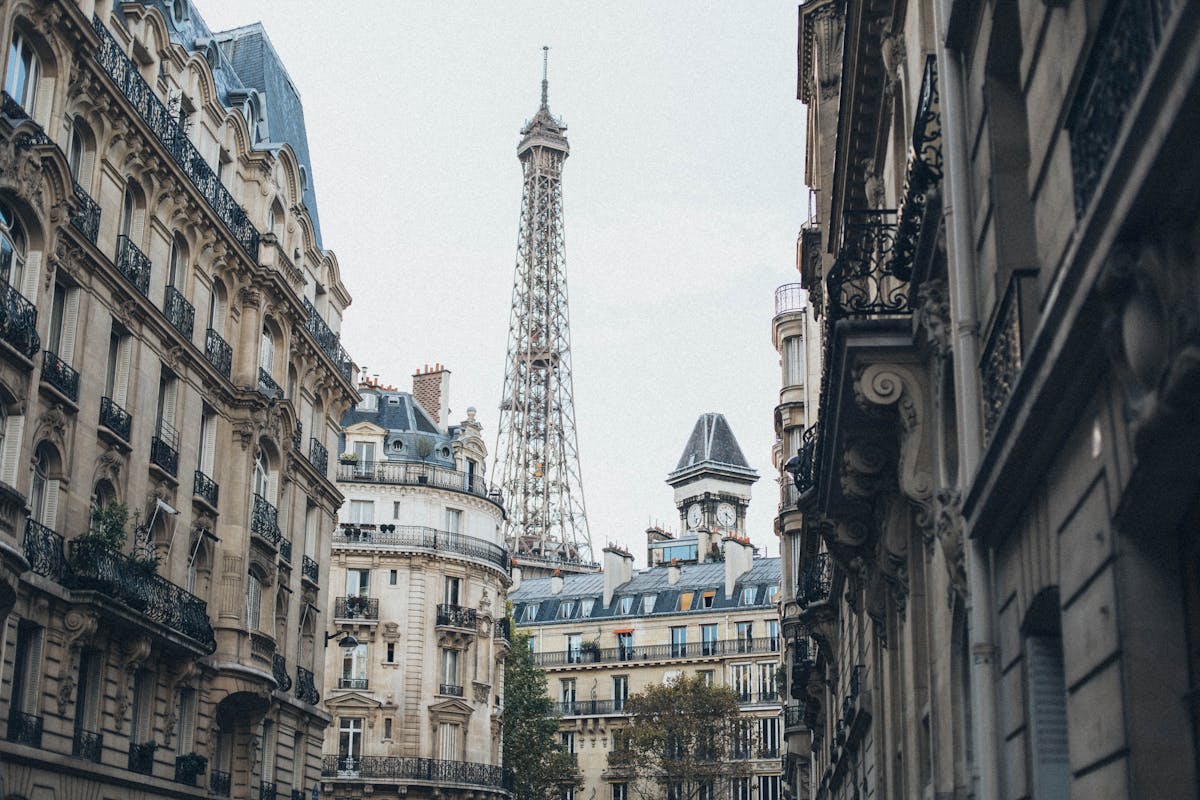 People walking along a Paris street past shops and cafes