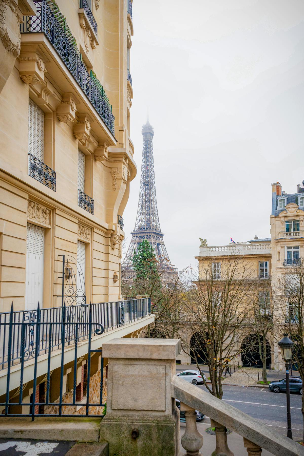 View of the Eiffel Tower framed by classic Parisian buildings with autumn trees