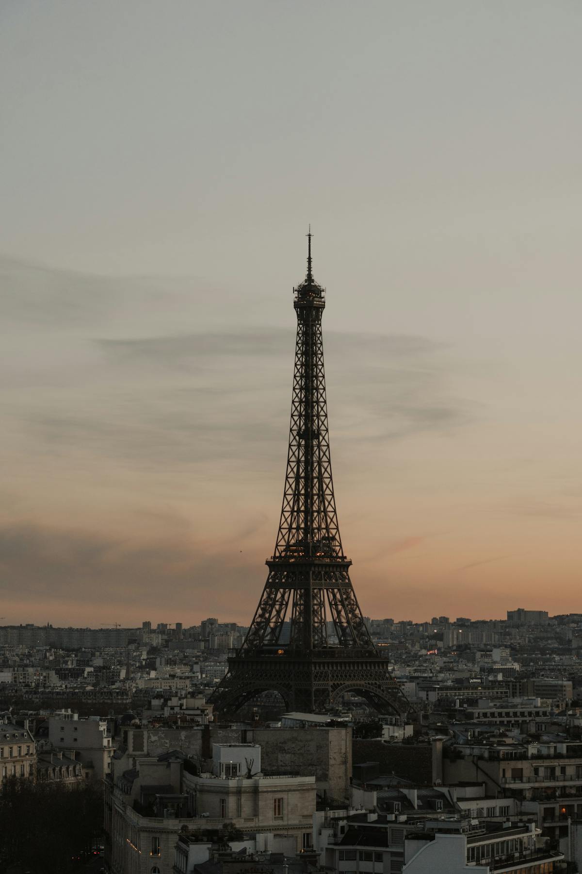 Eiffel Tower silhouette against orange and purple sunset sky over Paris