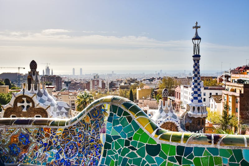 View of Barcelona from Park Guell showcasing mosaic architecture and city skyline