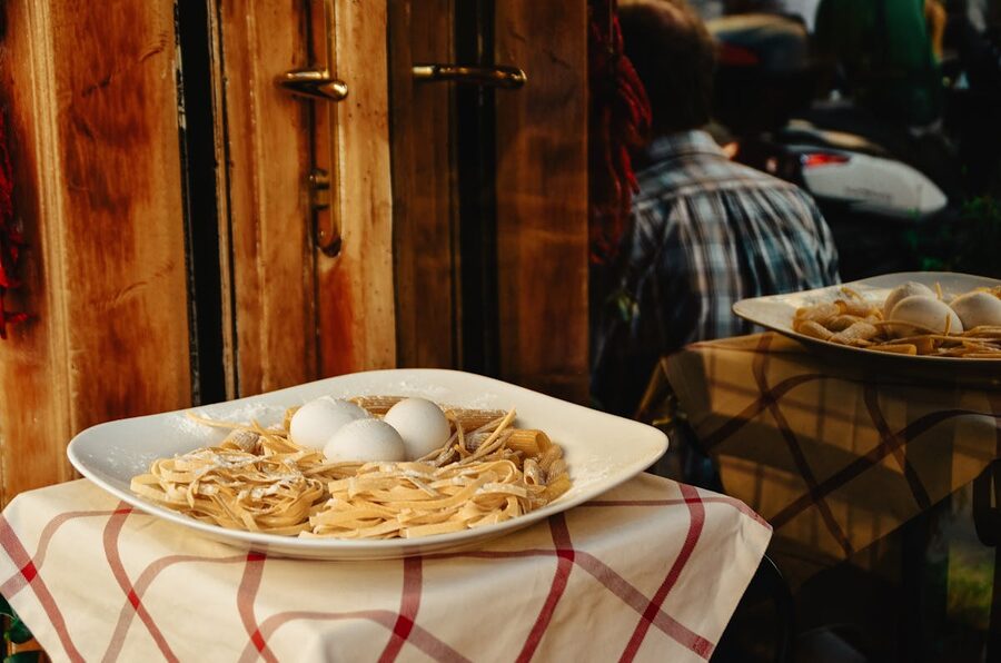 A plate of fresh pasta with eggs displayed outside a restaurant in Rome