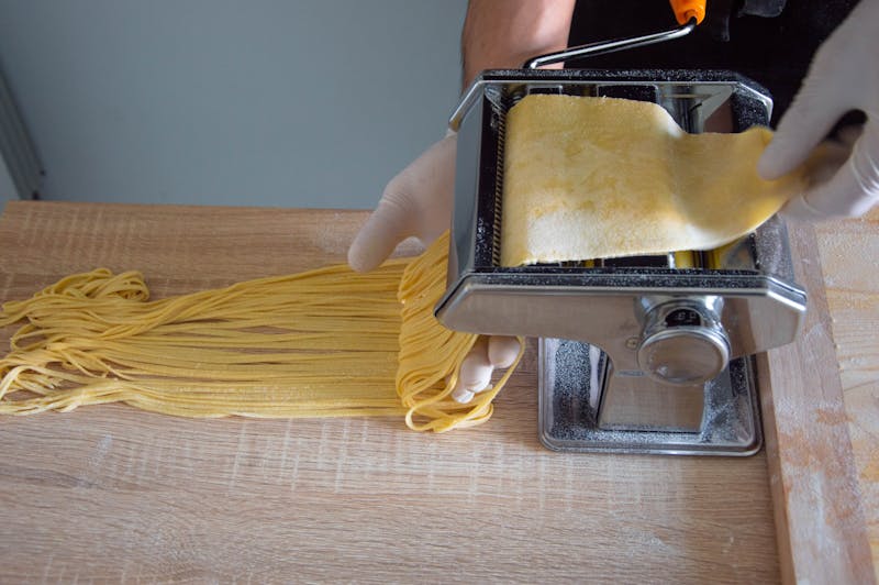 Close-up of pasta maker creating fresh spaghetti in a Roman kitchen