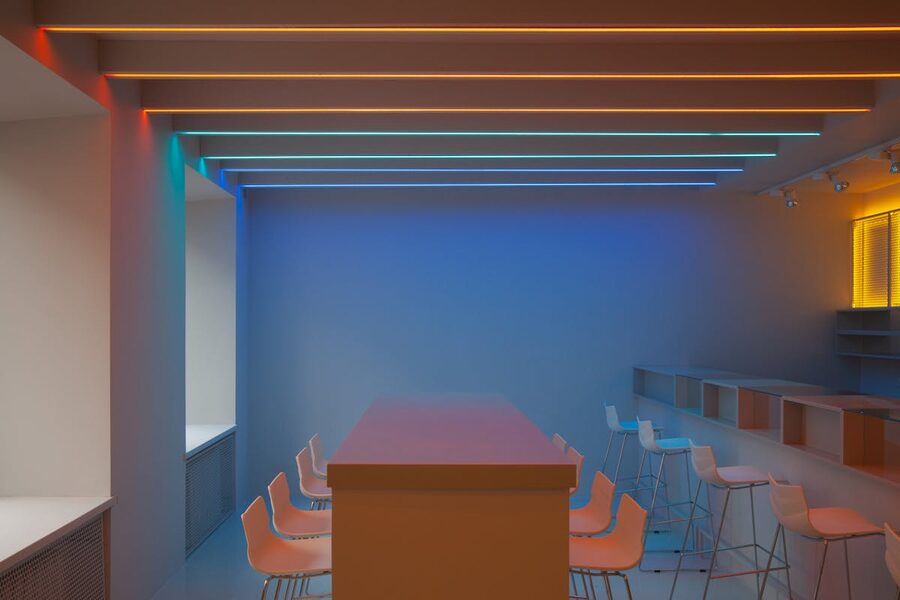 Minimalist room featuring colorful neon lighting and modern furniture design