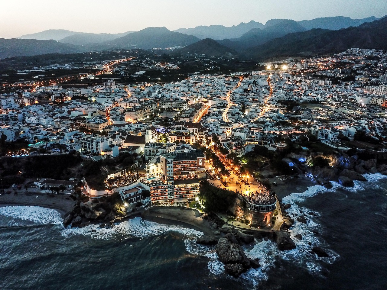 Nerja town at dusk with lights reflecting on the sea from Balcon de Europa