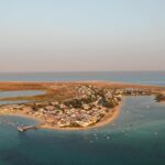 Aerial view of the Algarve coastline near Olhão with sandbar islands and calm lagoon waters at golden hour