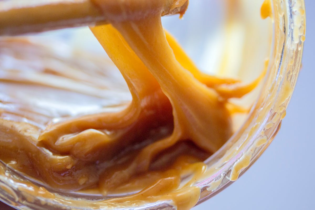 Detailed close-up of smooth gooey caramel showing its rich golden texture